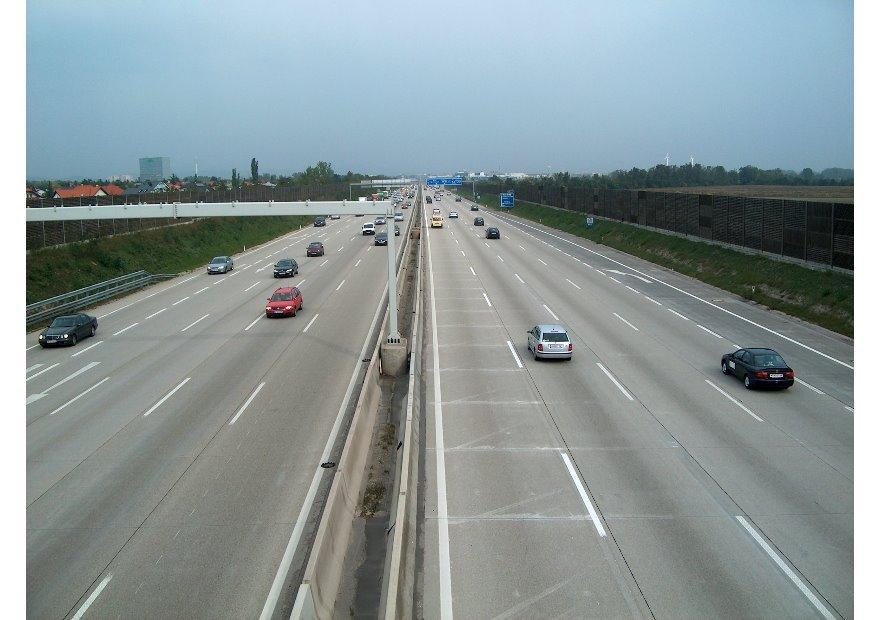 Foto van autosnelweg met meerdere rijstroken en voertuigen die in beide